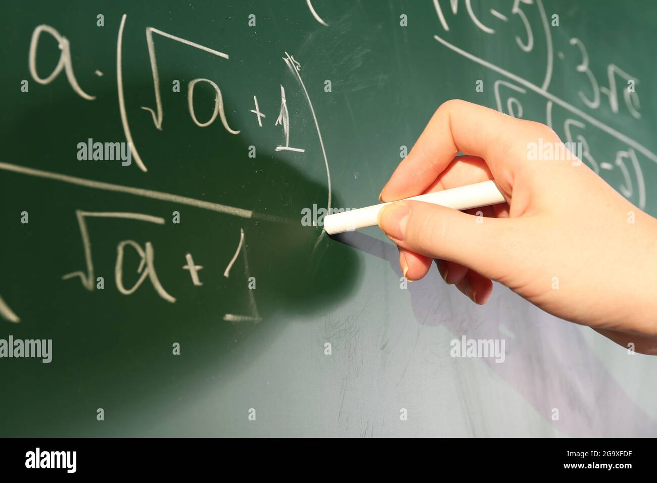 Teacher hand writing formulas on blackboard background Stock Photo - Alamy