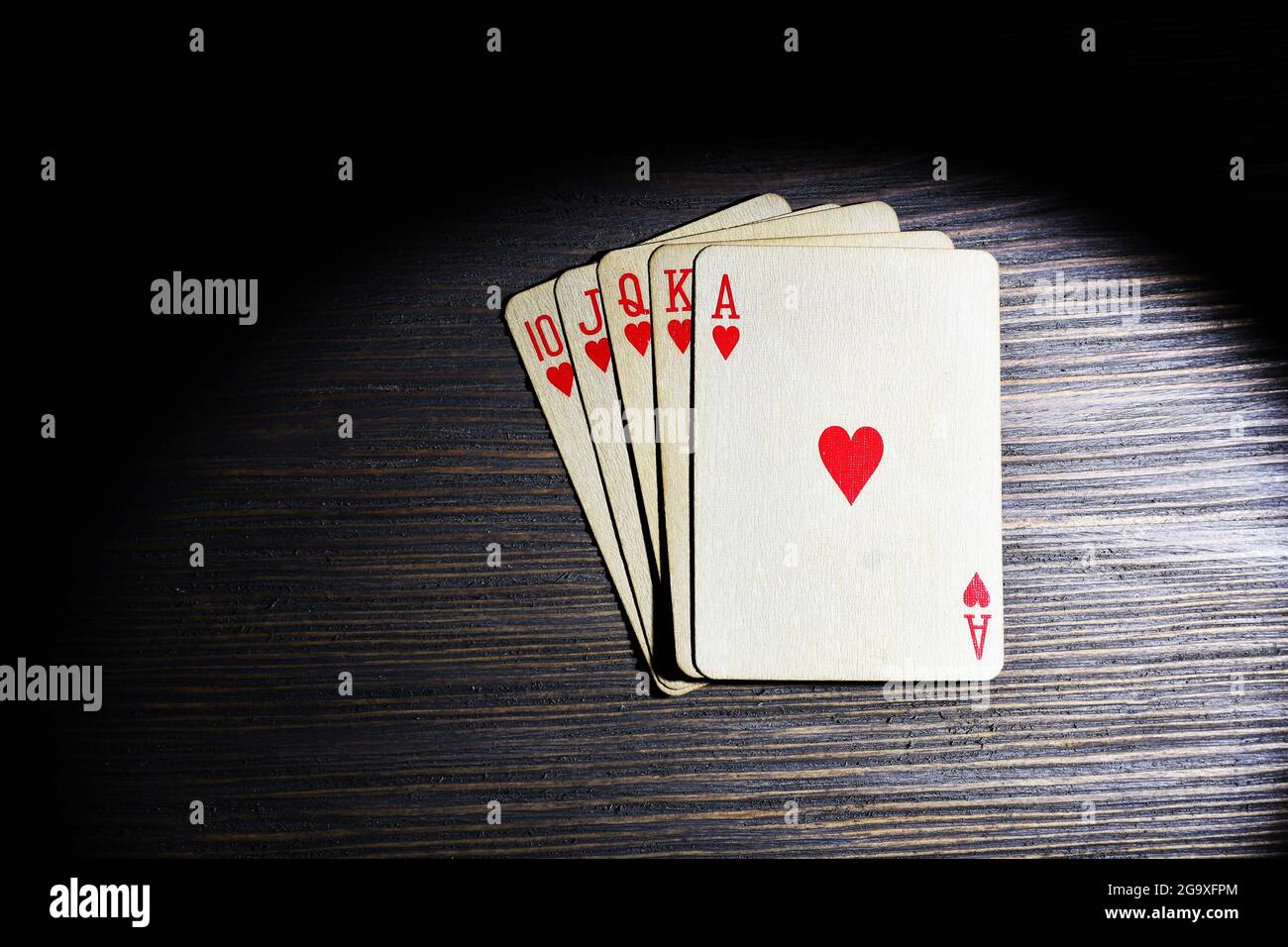 Playing cards in light on wooden table, top view Stock Photo - Alamy
