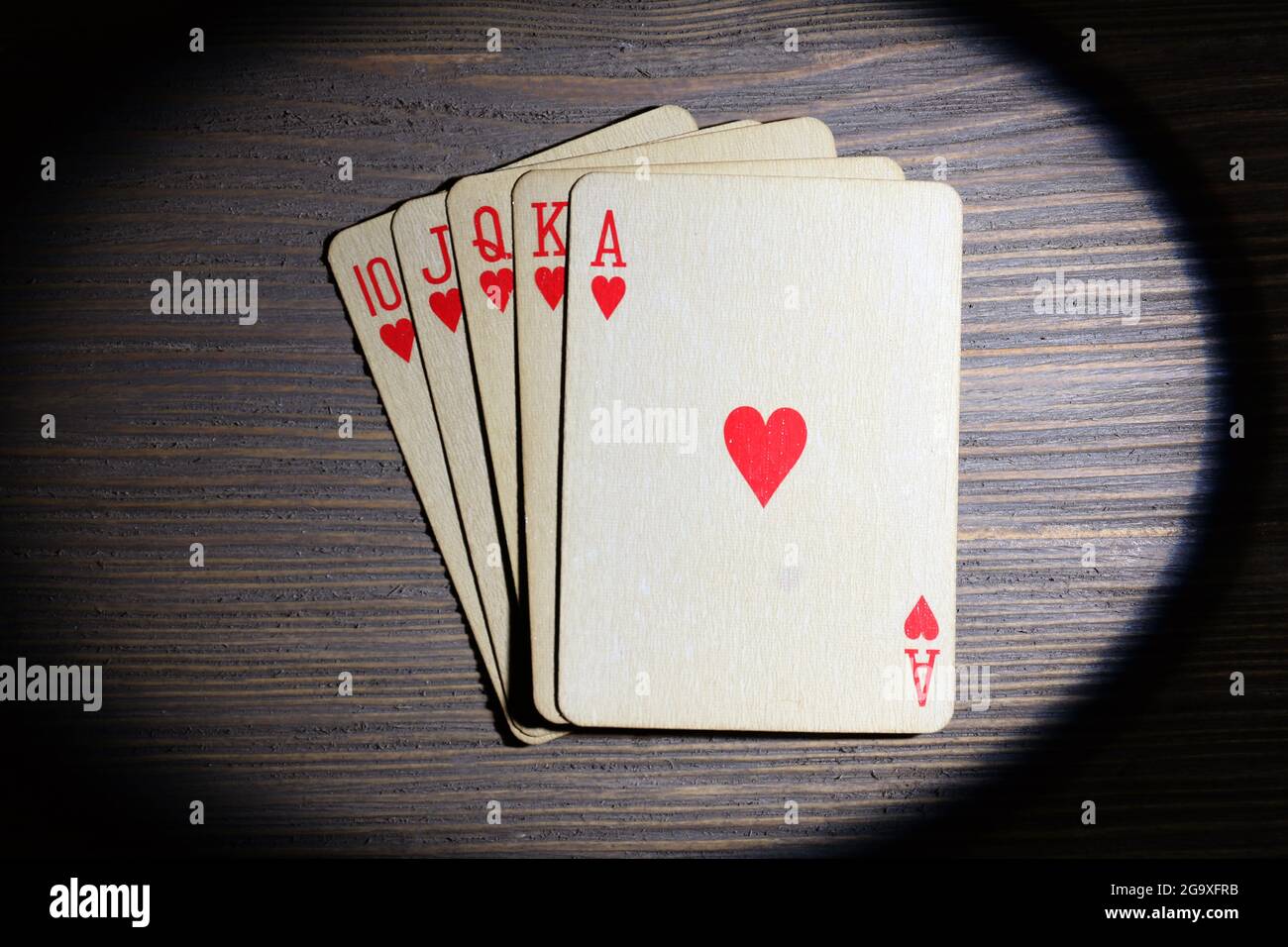 Playing cards in light on wooden table, top view Stock Photo - Alamy