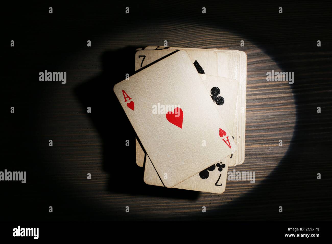 Stack of playing cards in light on wooden table, top view Stock Photo ...