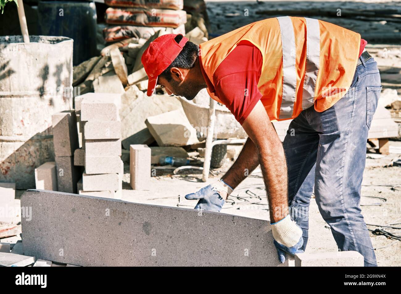 Turkish pavement construction worker grabbing a big tile of pavement ...