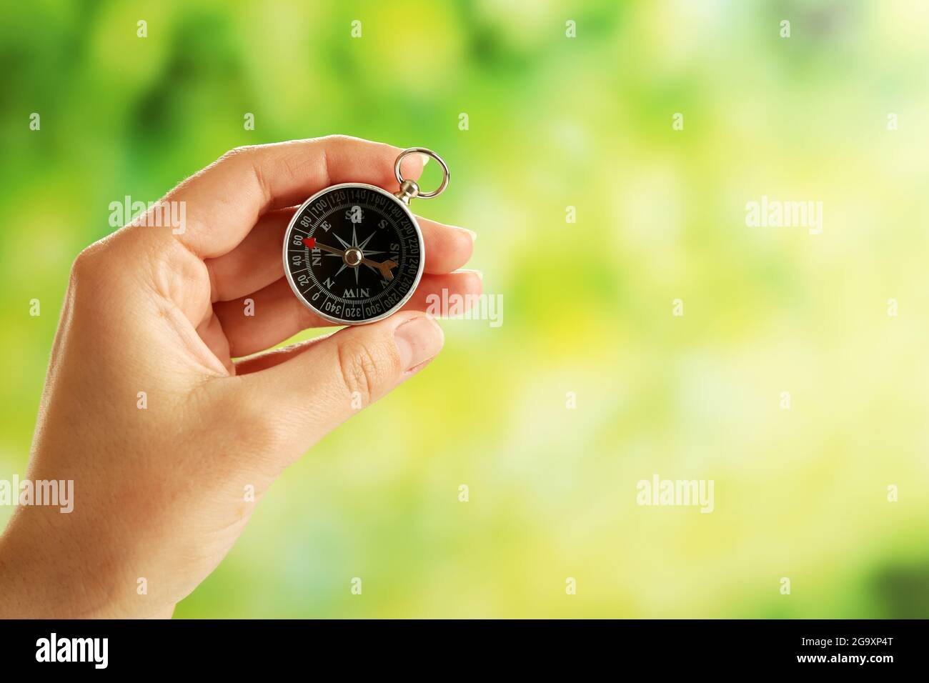 Female hand with compass on bright blurred background Stock Photo - Alamy