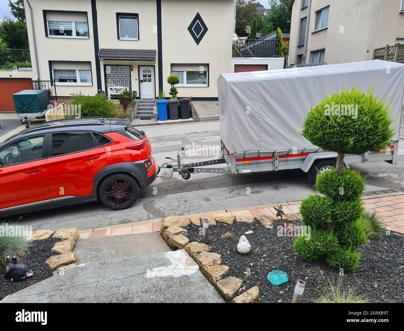 Compact SUV with gray awning single-axle trailer up close Car with ...