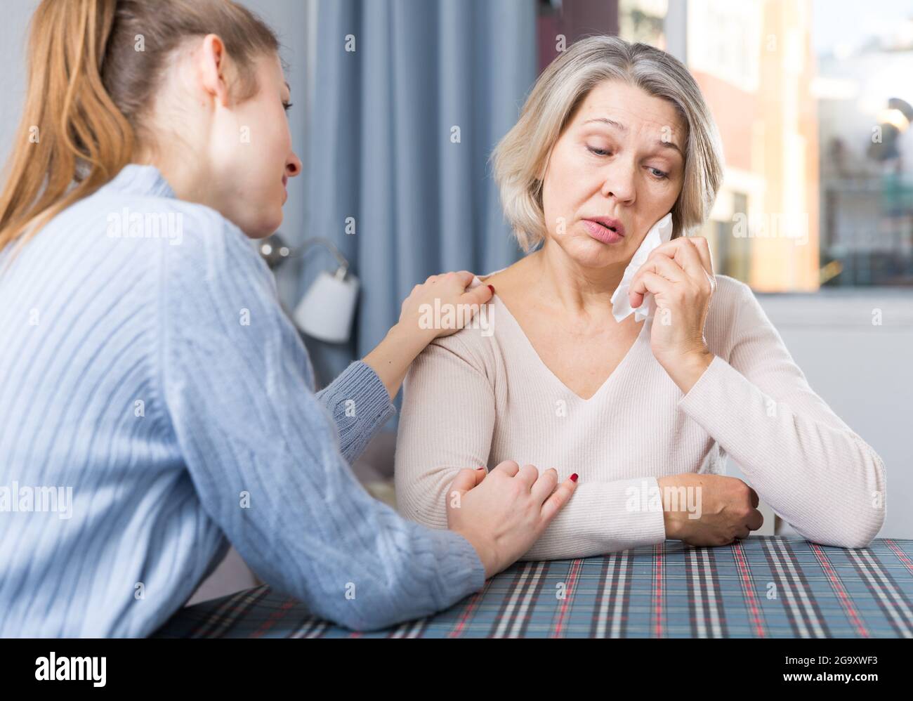 Girl supporting her crying mother Stock Photo - Alamy