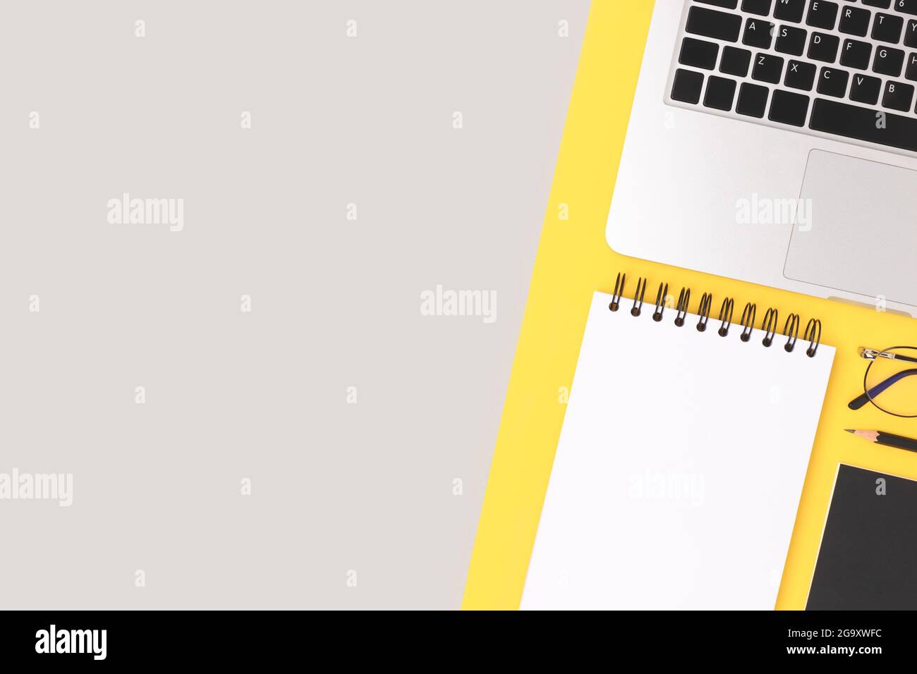Layout of stationery and laptop on a gray and yellow background. Neat ...