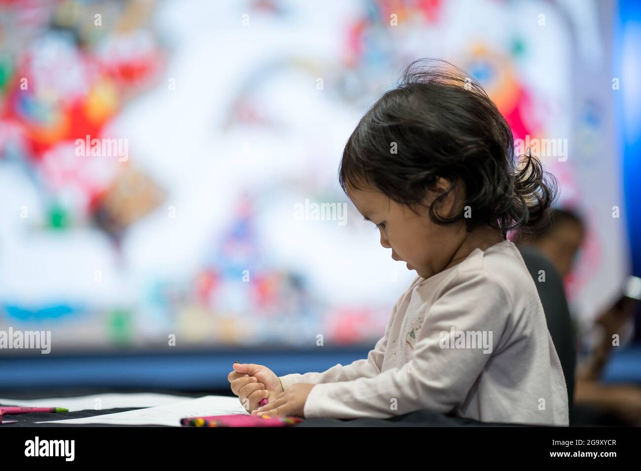 Southeast Asian female kid drawing on her paper Stock Photo - Alamy