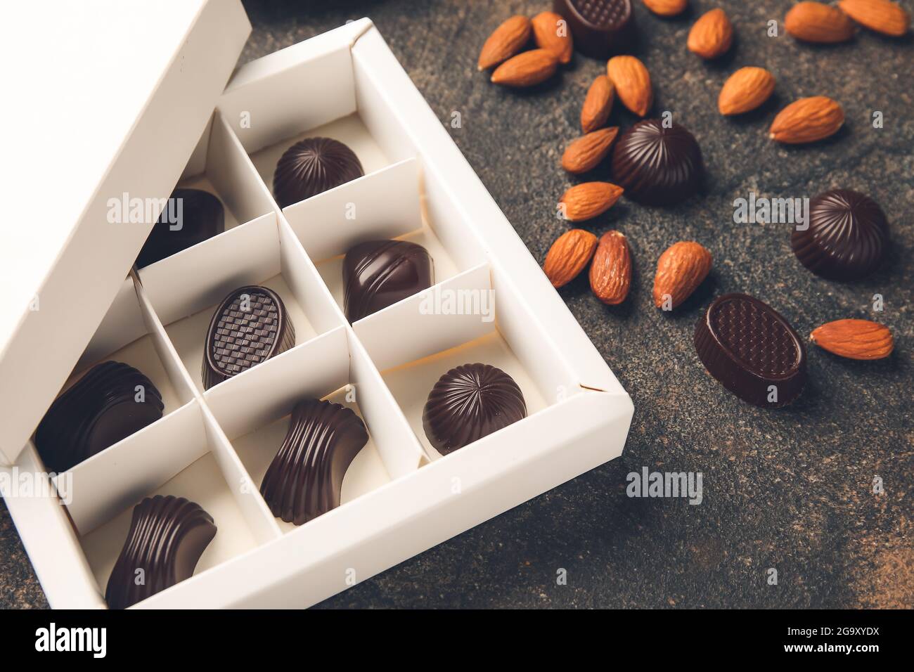 Box with sweet chocolate candies and nuts on grunge background Stock ...