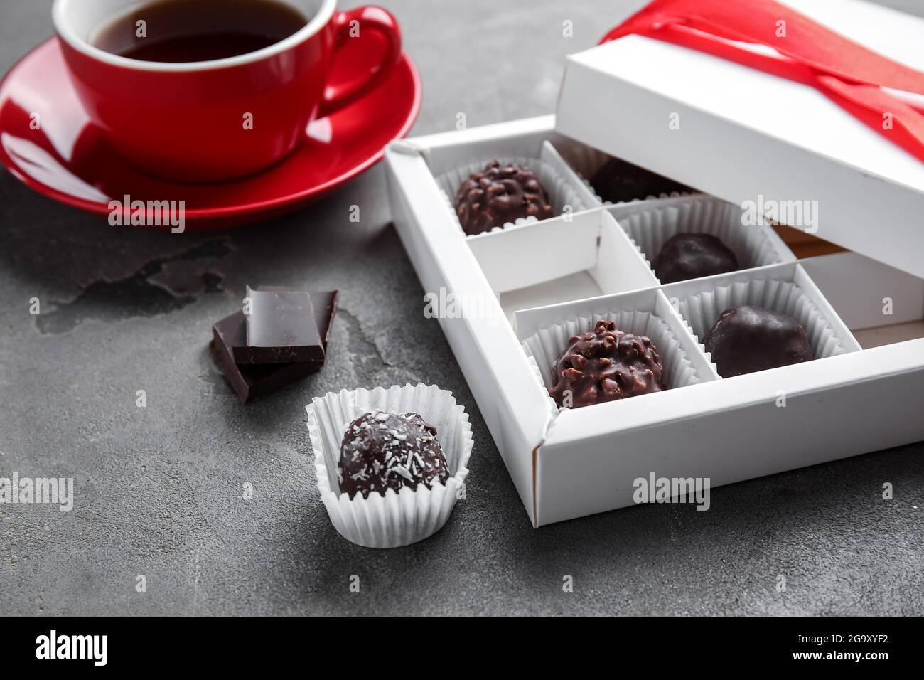 Box with sweet chocolate candies and tea on grunge background Stock ...
