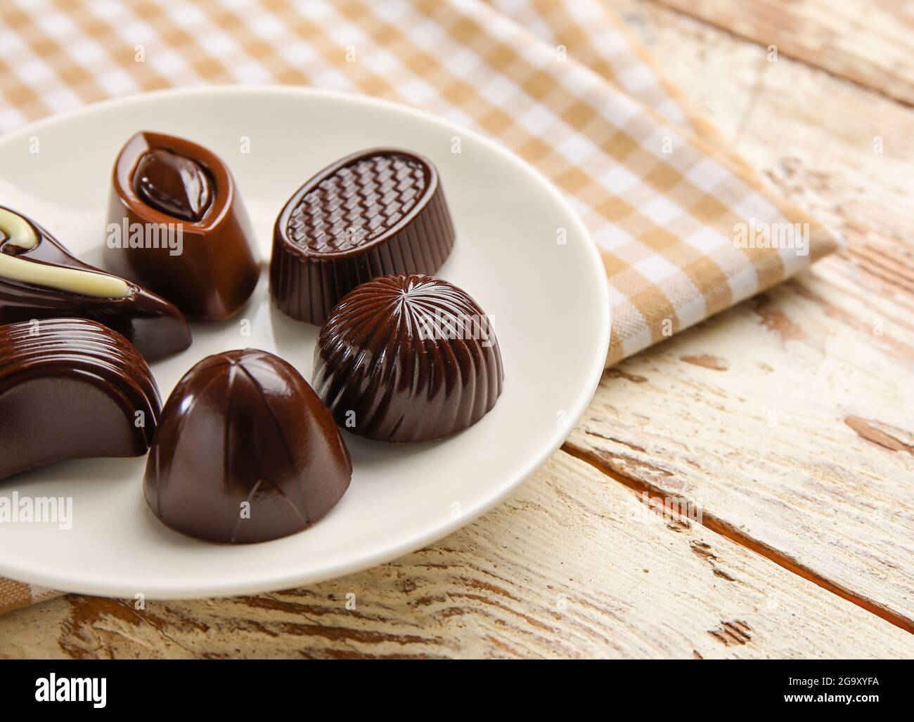 Plate with sweet chocolate candies on table Stock Photo - Alamy