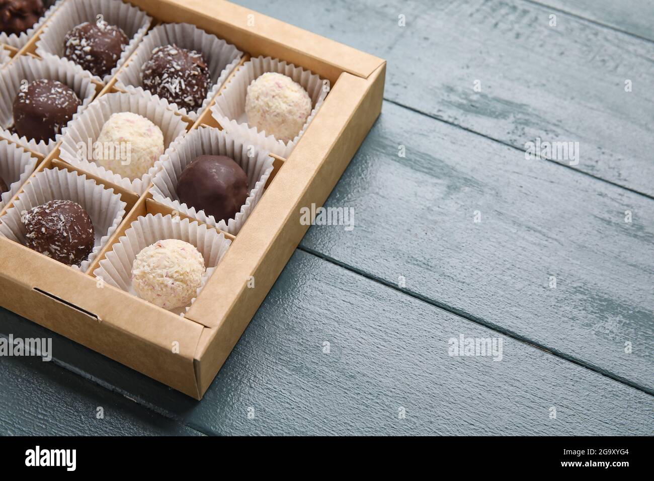 Box with sweet chocolate candies on wooden background Stock Photo - Alamy