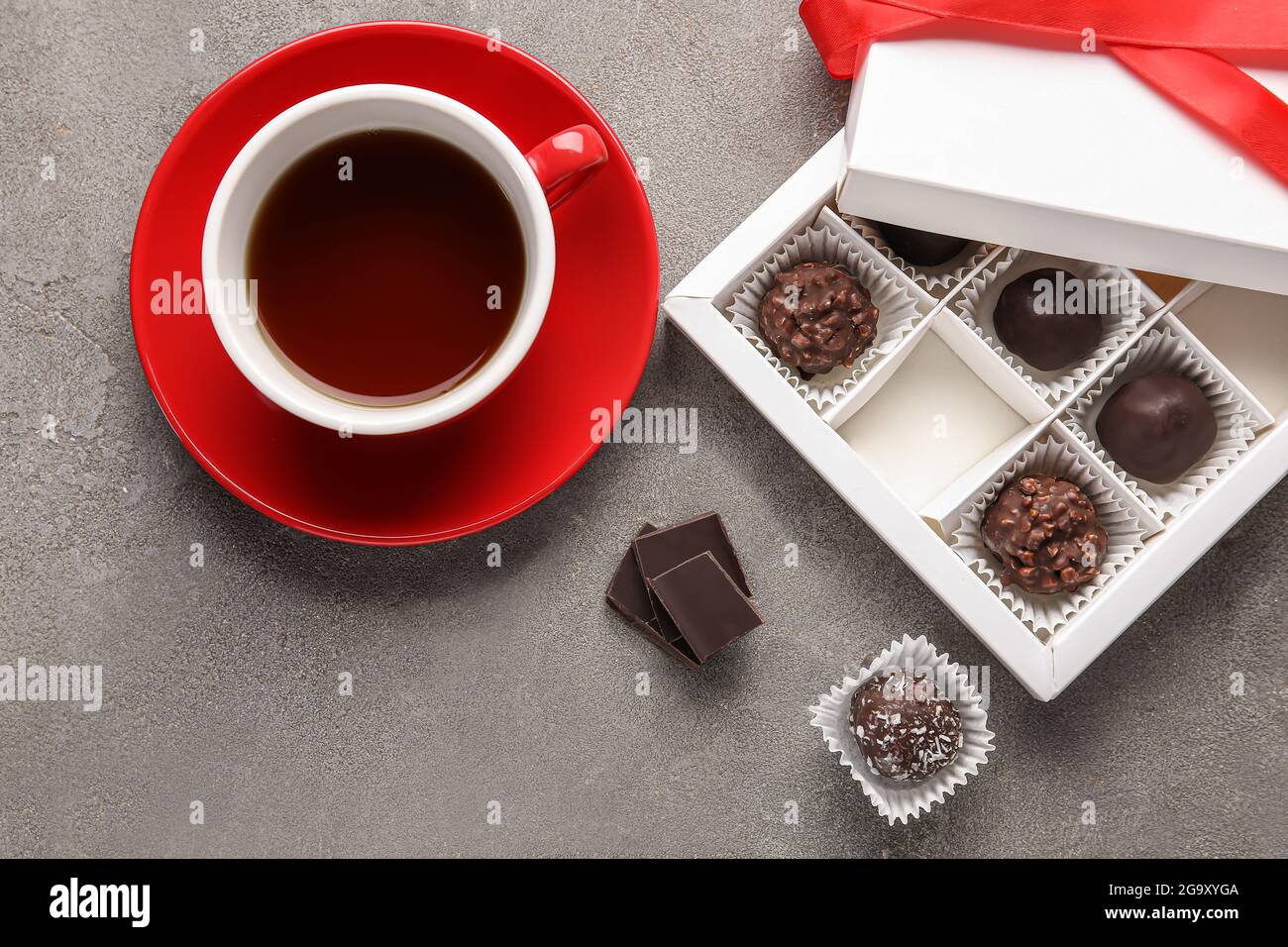 Box with sweet chocolate candies and tea on grunge background Stock ...