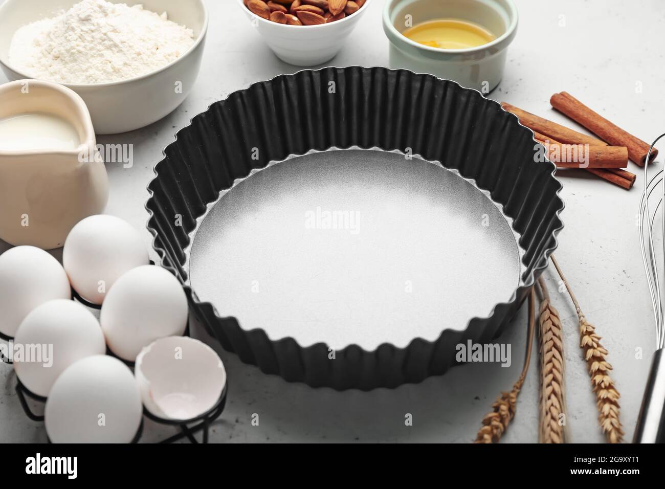 Baking form with ingredients for preparing cake and utensils on light ...
