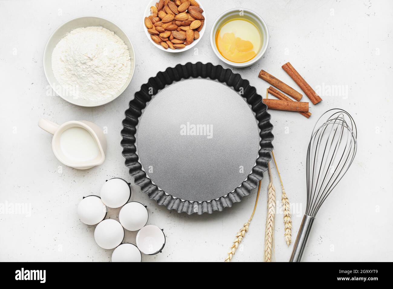 Baking form with ingredients for preparing cake and utensils on light ...