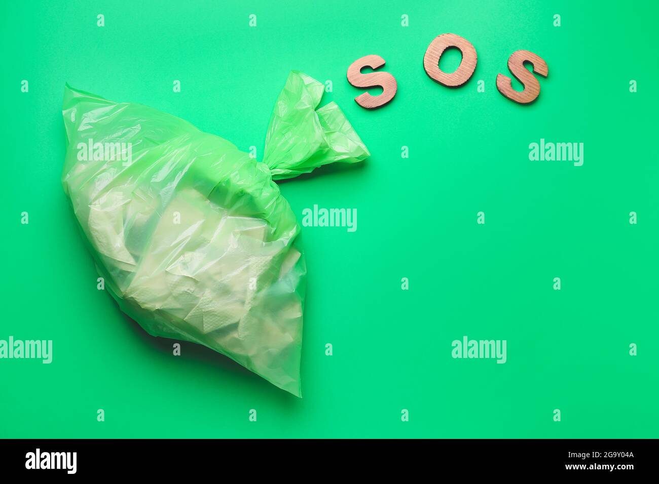 Bag with garbage and word SOS on color background. Ecology concept ...