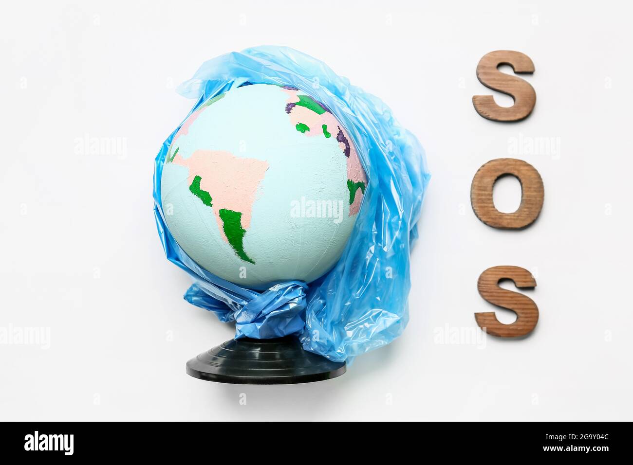 Globe in garbage bag with word SOS on white background. Ecology concept ...