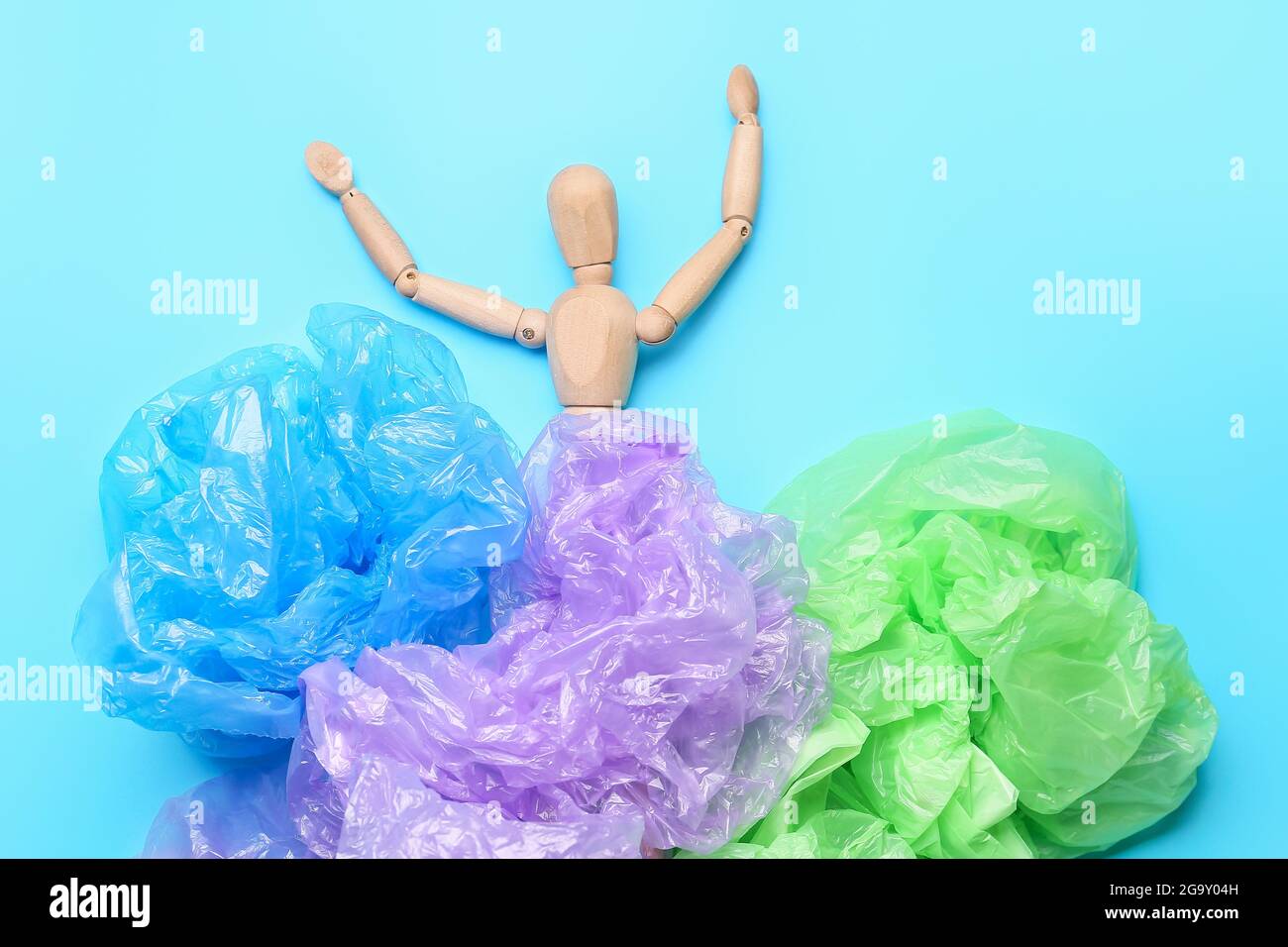 Wooden mannequin with garbage bags on color background. Ecology concept ...