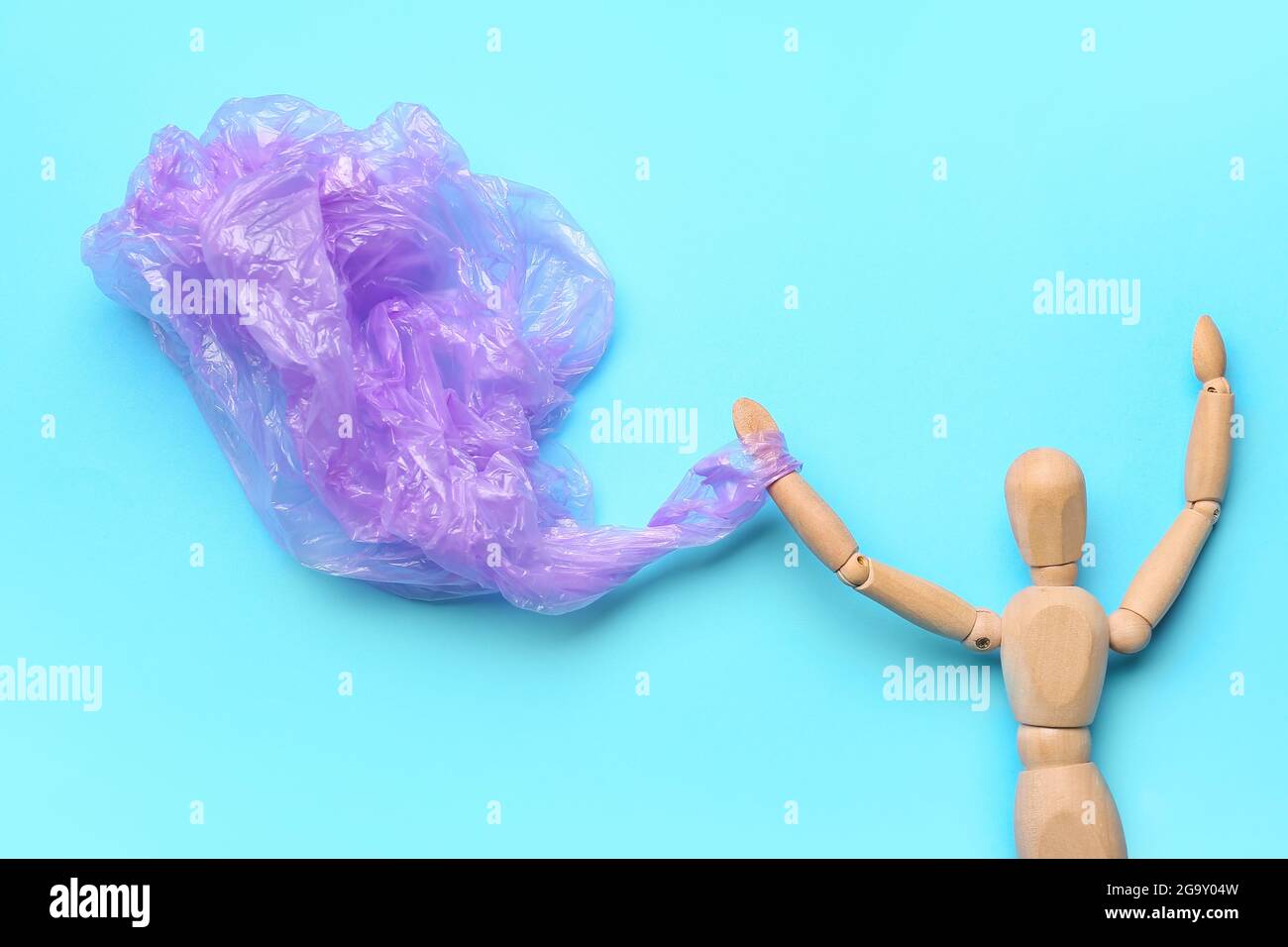 Wooden mannequin with garbage bag on color background. Ecology concept ...