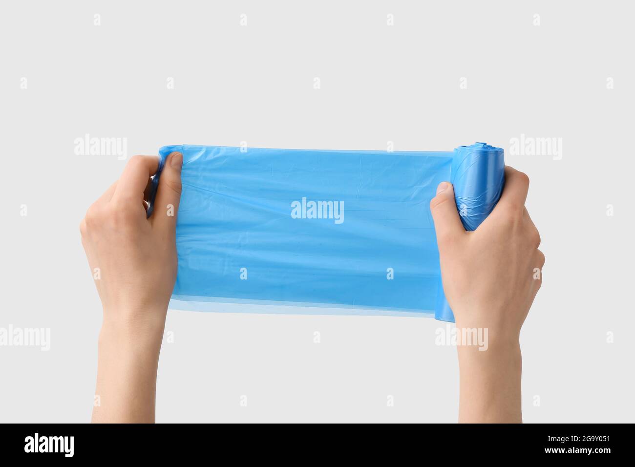 Female hands unwinding garbage bag on white background Stock Photo - Alamy