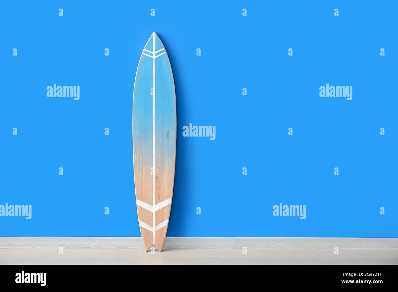 Blue surfboard near color wall Stock Photo - Alamy