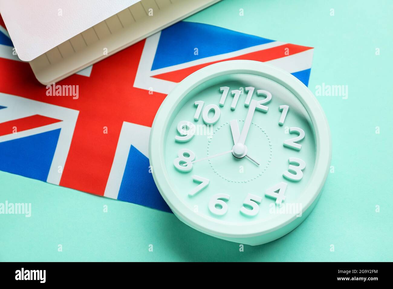 Clock and UK flag on color background. Time to learn English Stock ...