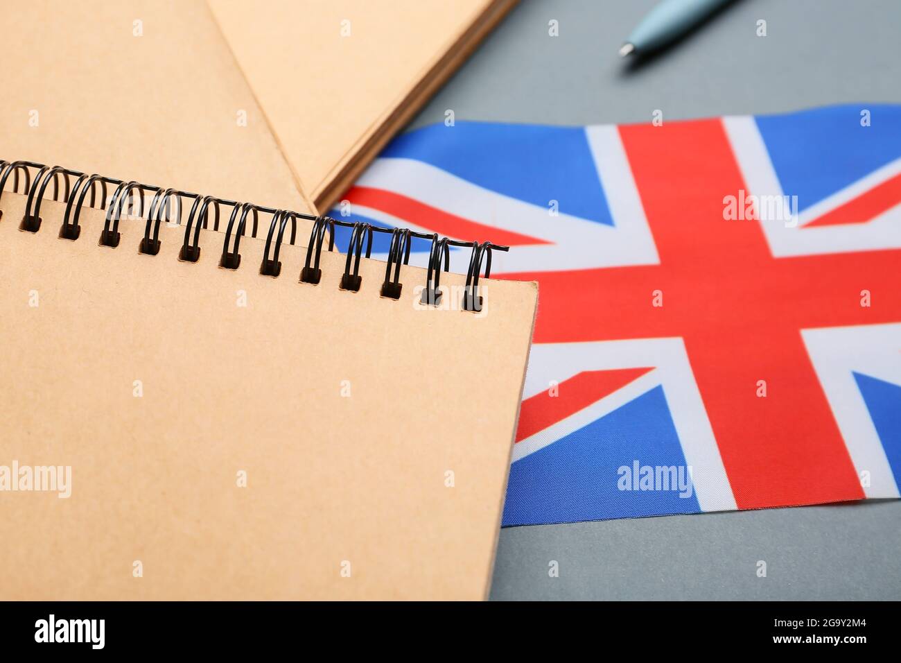 Notebooks and UK flag on grey background, closeup. Concept of learning ...