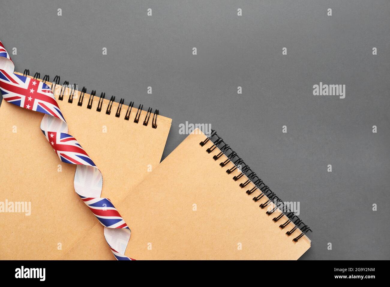 Notebooks and ribbon in colors of UK flag on grey background. Concept ...