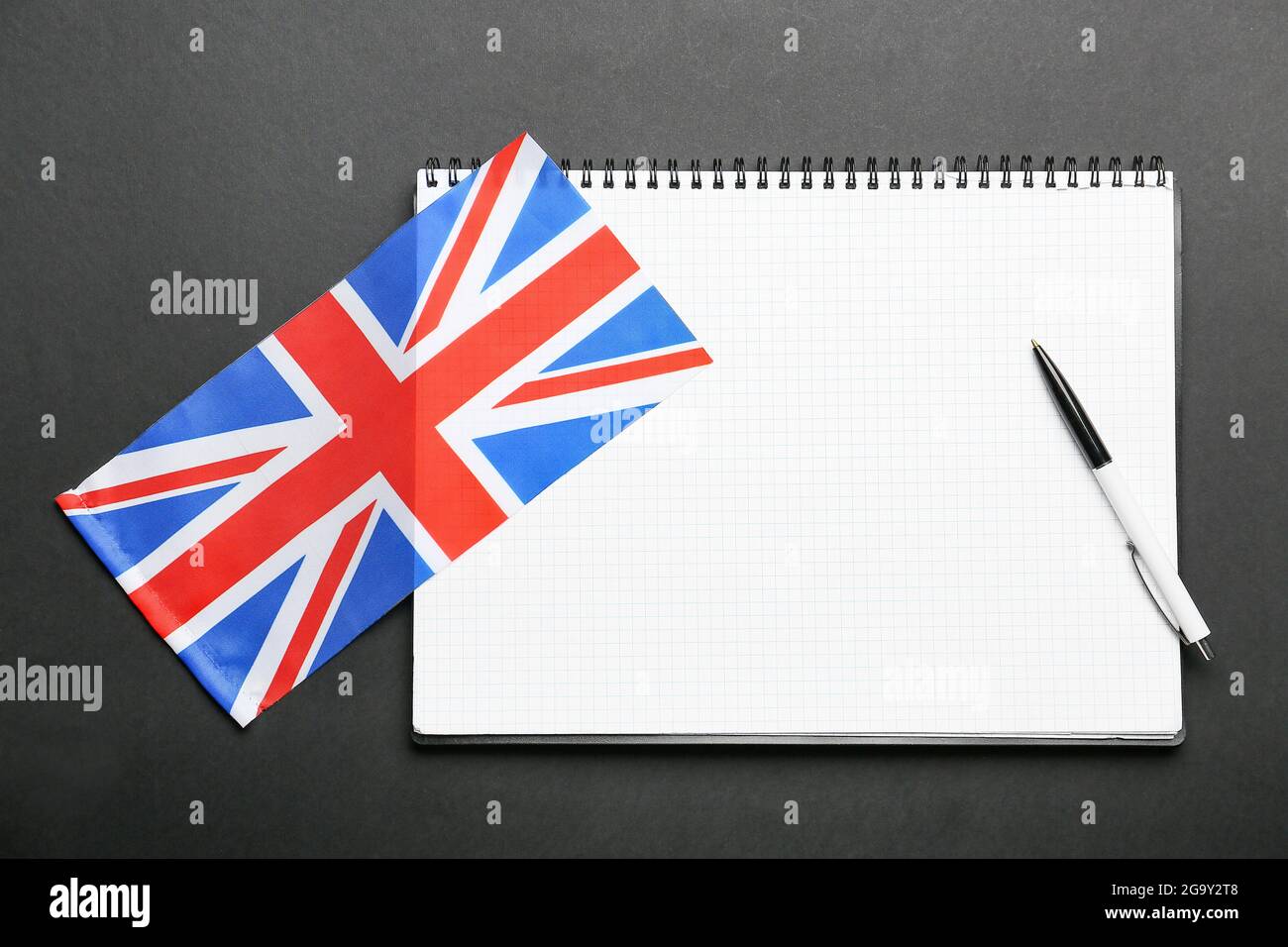 Notebook, pen and UK flag on dark background. Concept of learning ...
