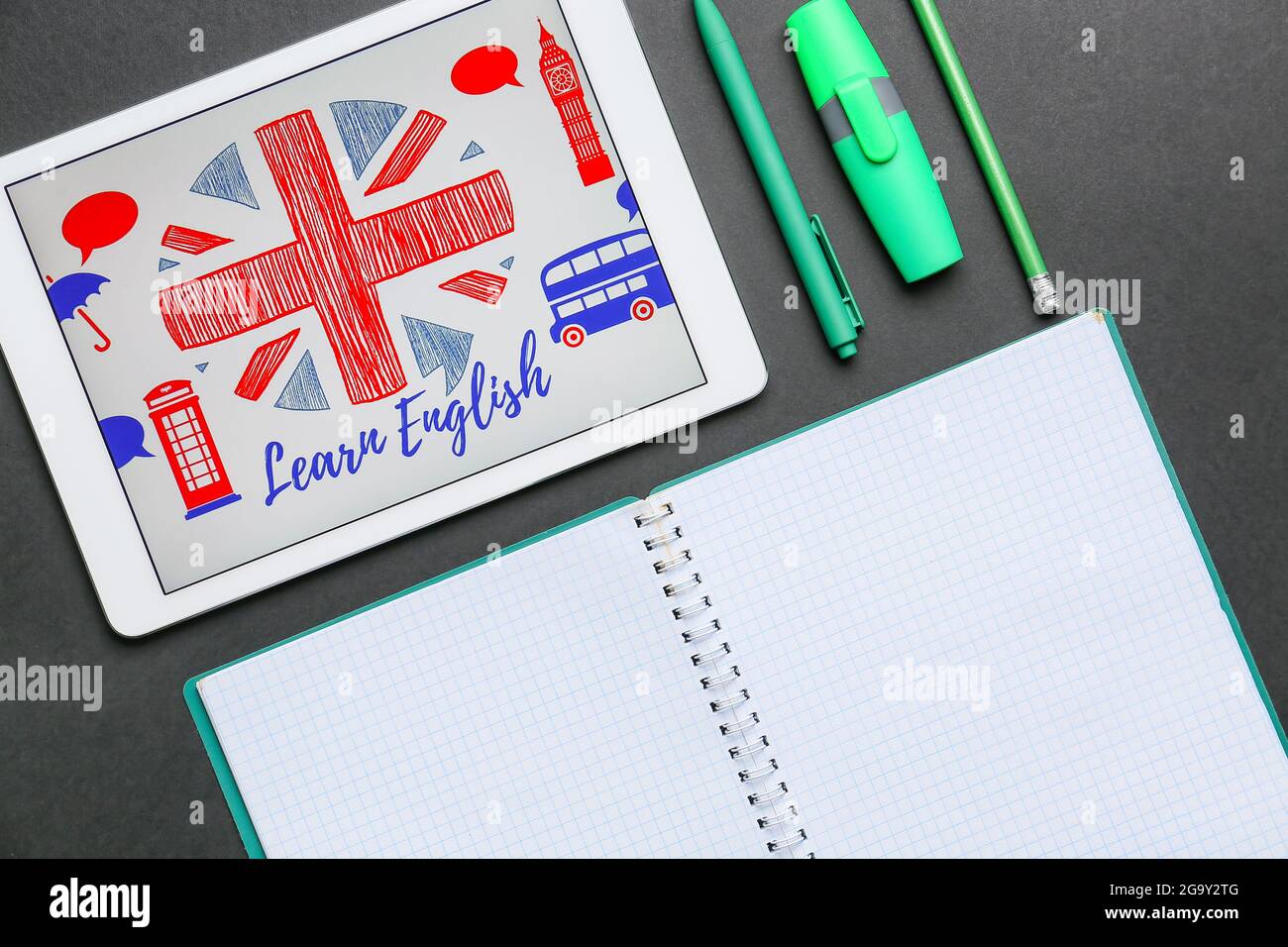 Tablet computer and stationery on dark background. Concept of learning ...