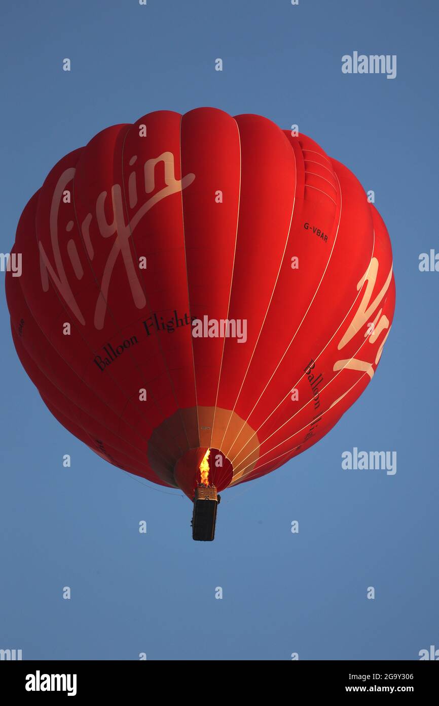 Peterborough, UK. 26th July, 2021. A red Virgin hot air balloon flies ...