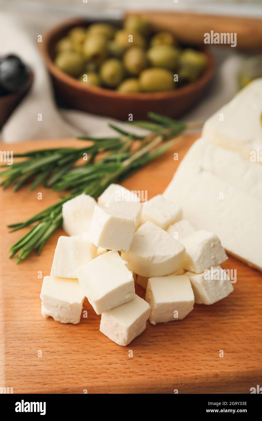 Delicious pieces of feta cheese on board Stock Photo - Alamy