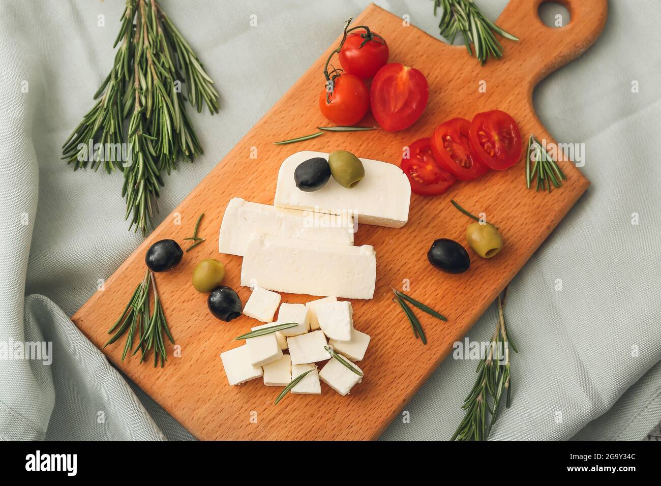 Delicious pieces of feta cheese on board Stock Photo - Alamy