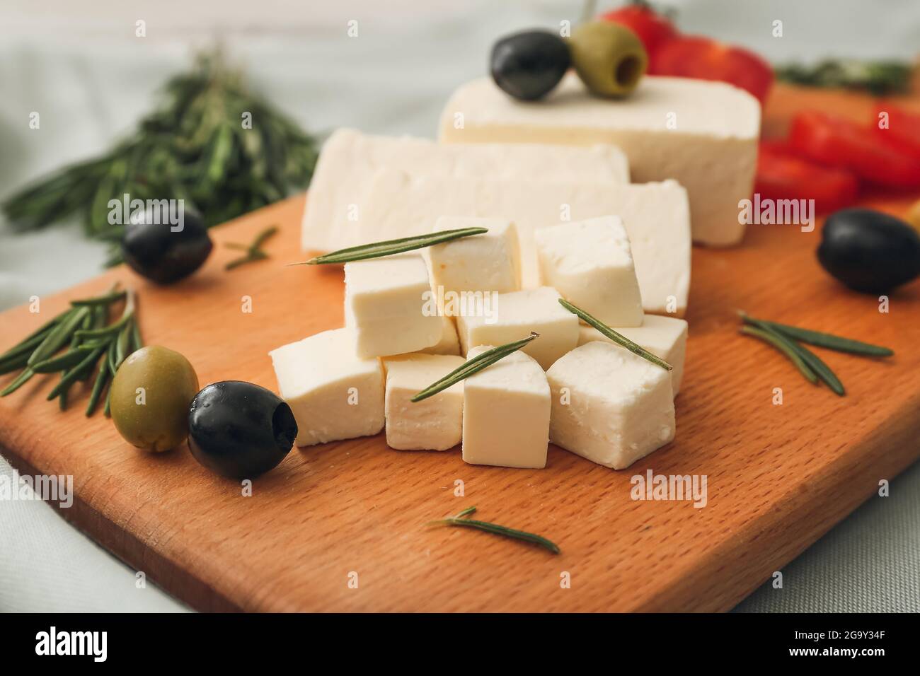 Delicious pieces of feta cheese on board Stock Photo - Alamy