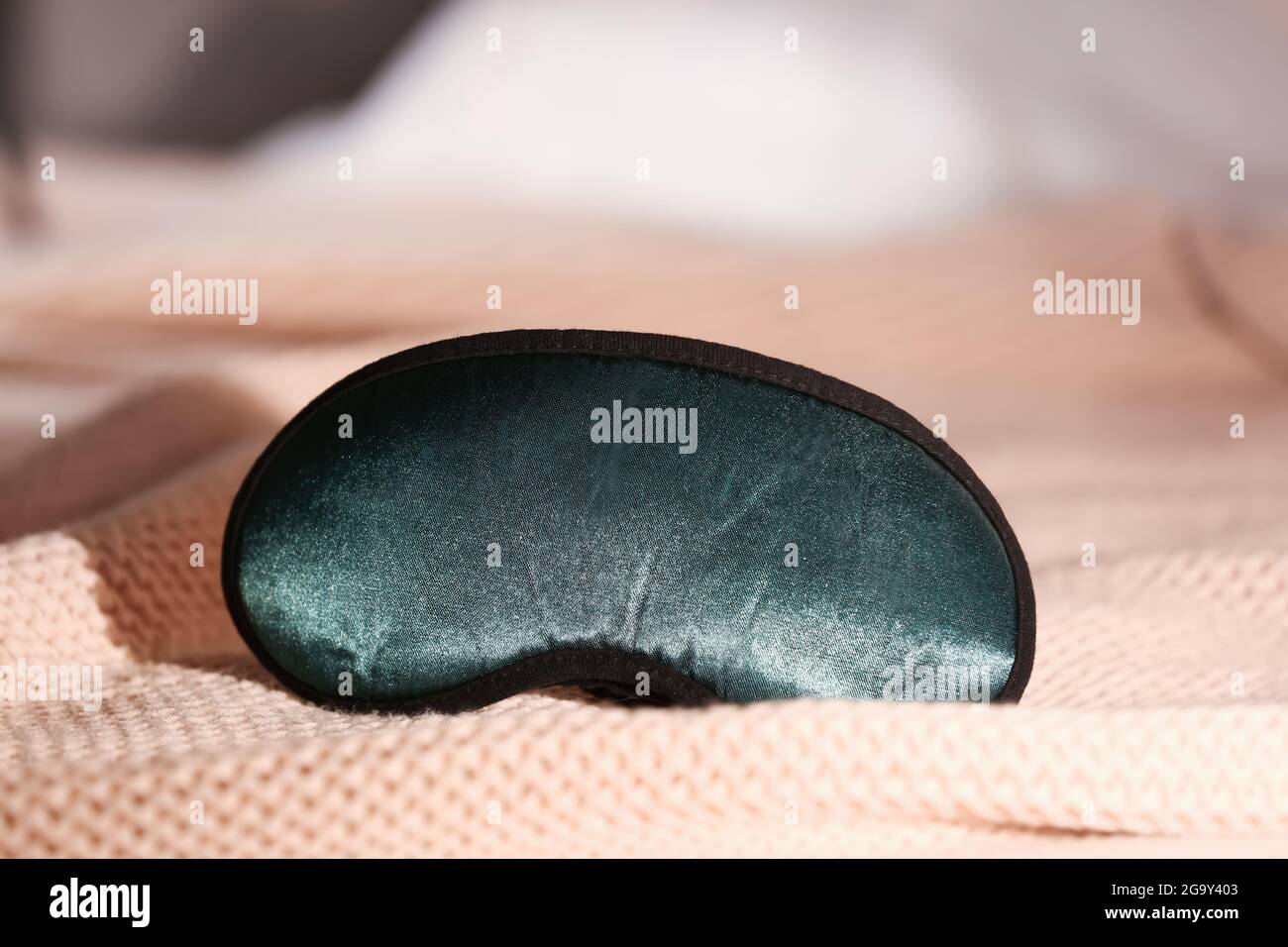 Stylish sleeping mask on bed in room Stock Photo - Alamy
