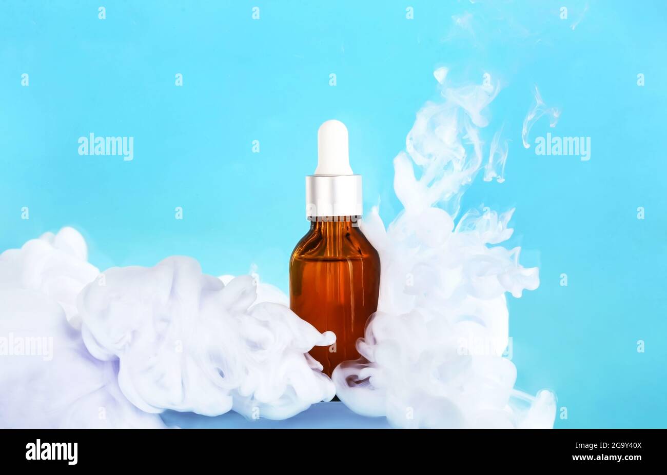 Bottle of cosmetic product in smoke on color background Stock Photo - Alamy