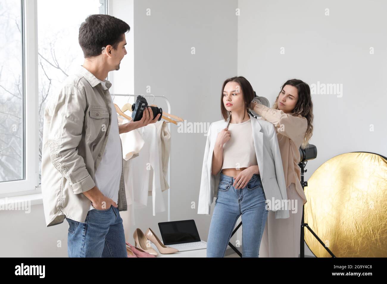 Stylist and photographer working with model in studio Stock Photo - Alamy