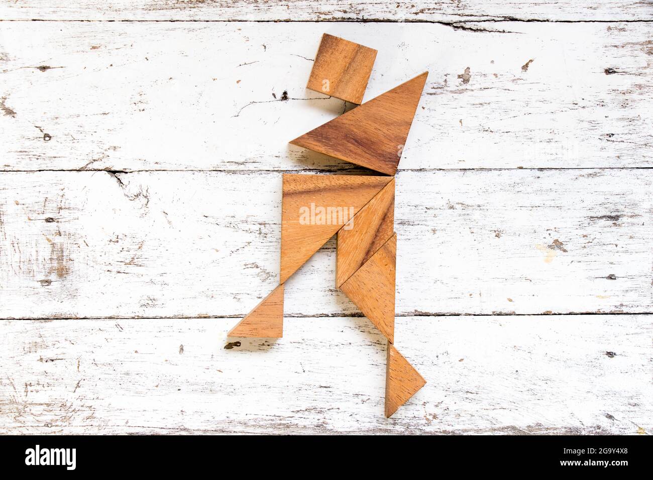Tangram puzzle in happy dancing man shape on old white wood background ...