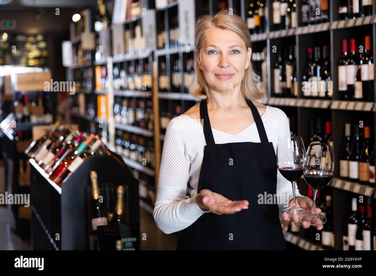 Woman owner of winery inviting to tasting wine Stock Photo - Alamy