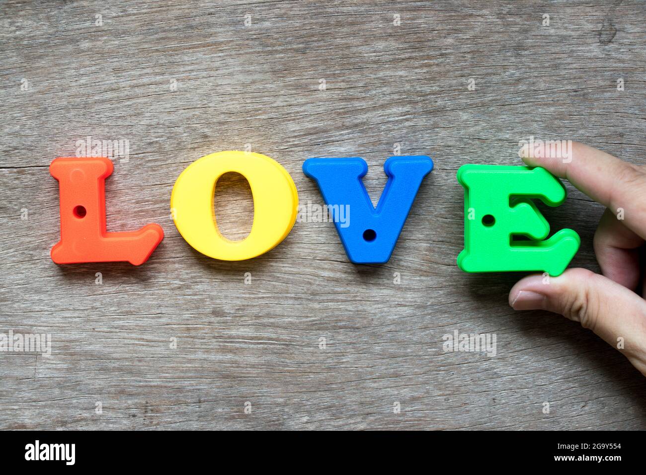 Colorful plastic alphabet in word love with hand hold e letter to ...