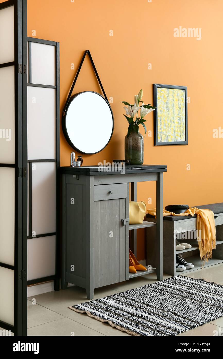 Interior of stylish hallway with folding screen Stock Photo - Alamy