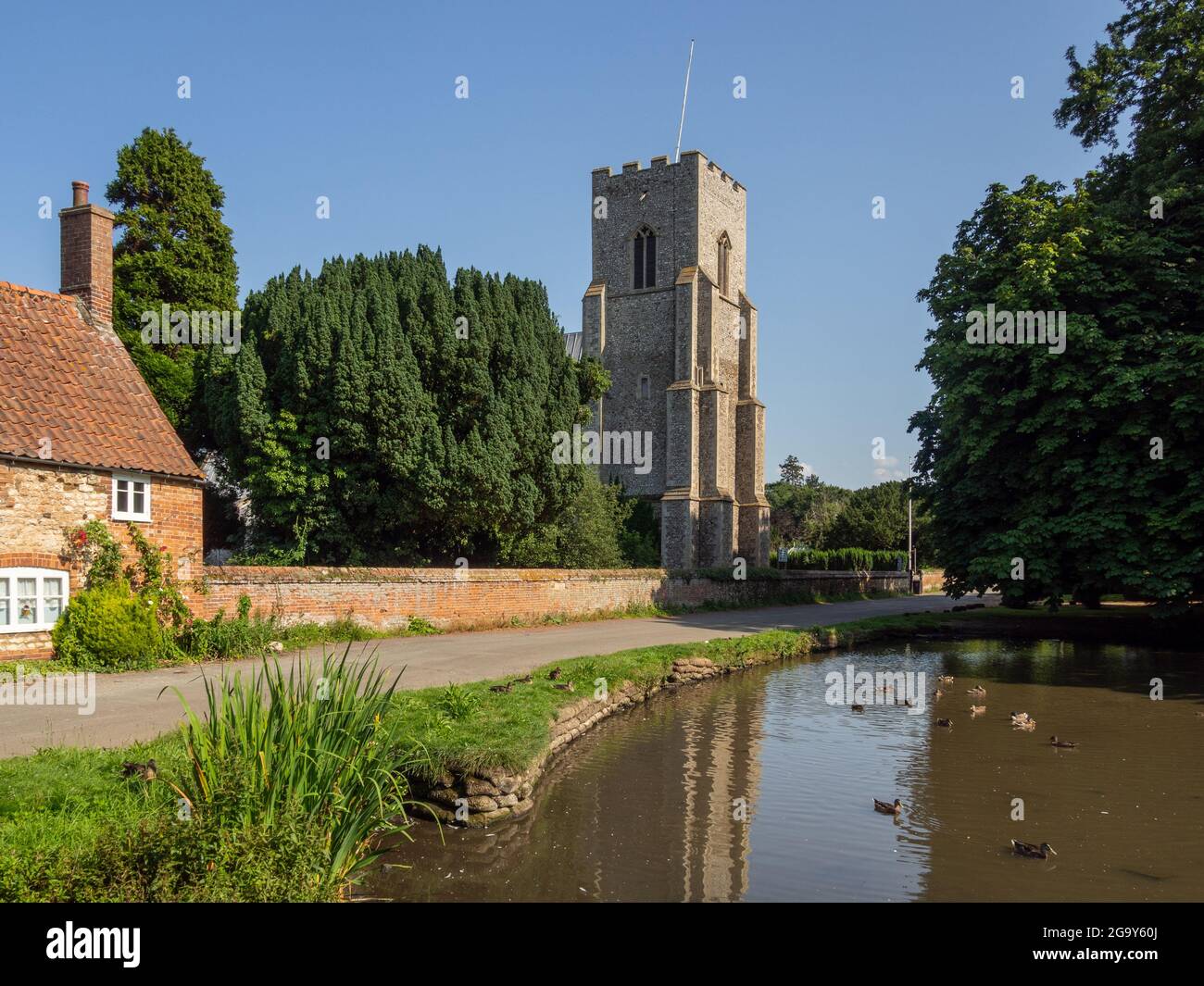 Idyllic English village scene in summer, view across a duck pond to a ...