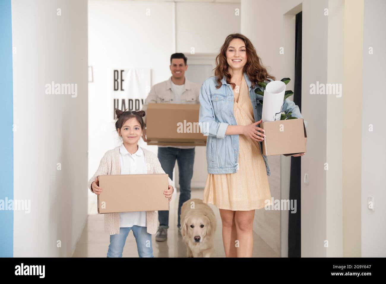 Happy family with boxes in their new house on moving day Stock Photo ...