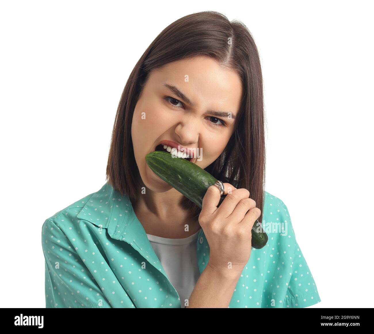 Angry young woman eating cucumber on white background Stock Photo - Alamy