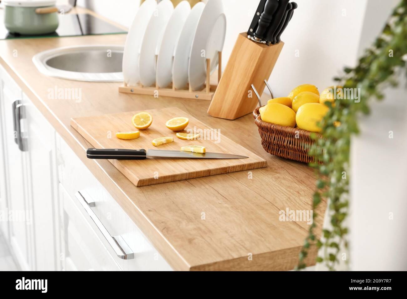 Board with knife and lemon on counter in kitchen Stock Photo - Alamy