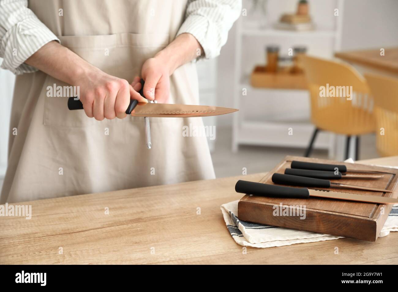 Woman sharpening knife in kitchen Stock Photo - Alamy