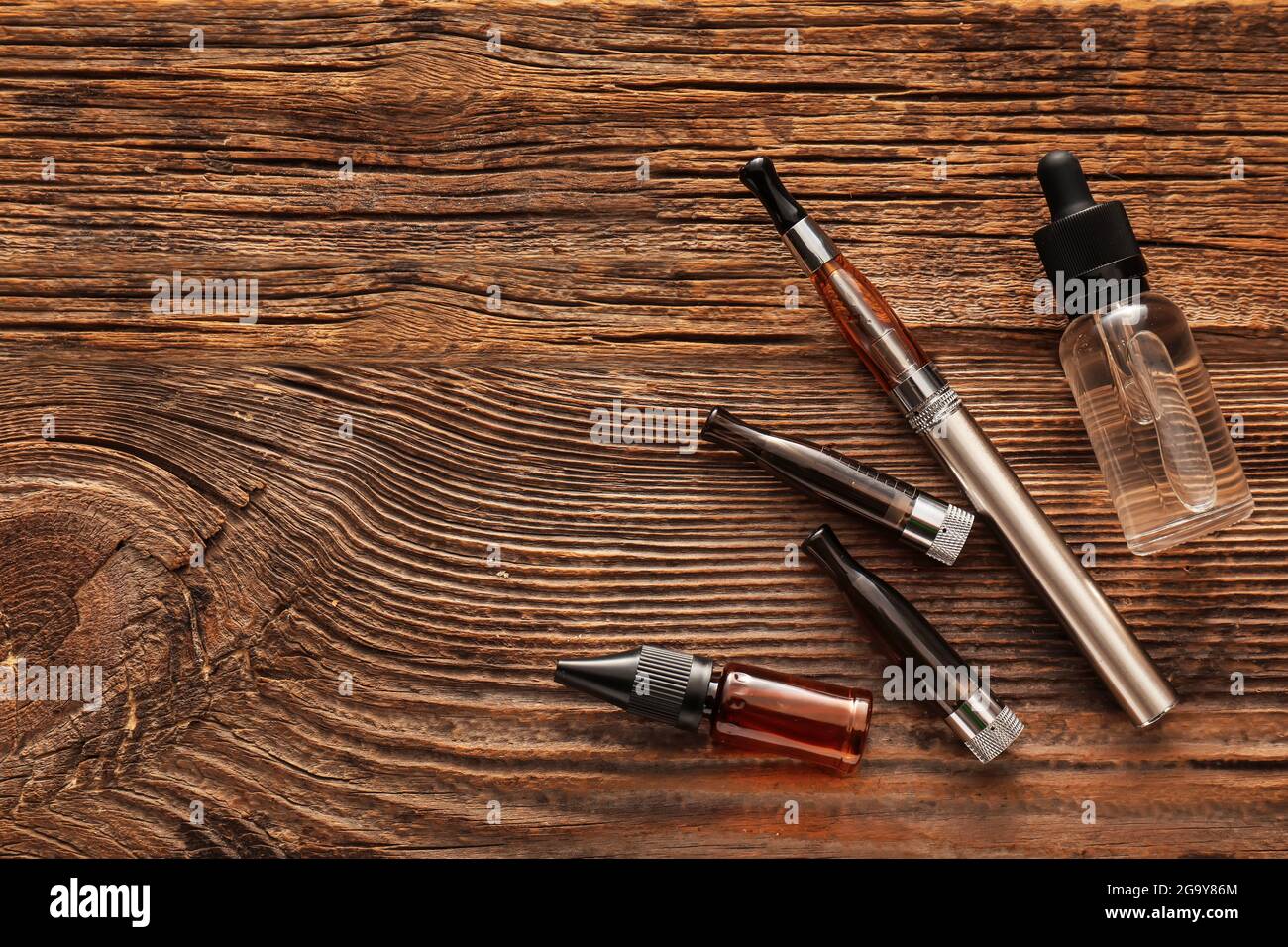 Electronic cigarette with oil on wooden background Stock Photo - Alamy