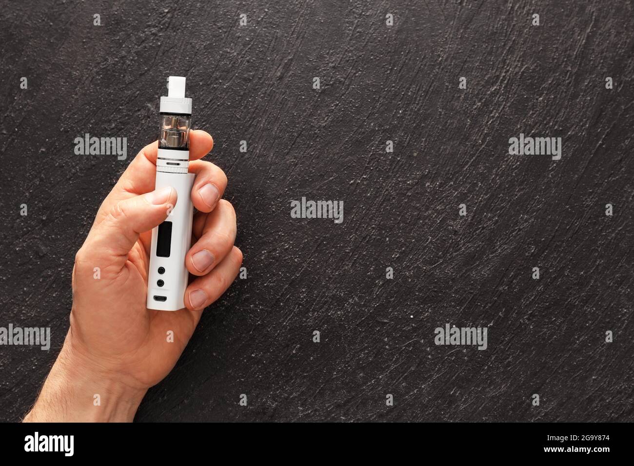 Male hand with vape mod on dark background Stock Photo - Alamy
