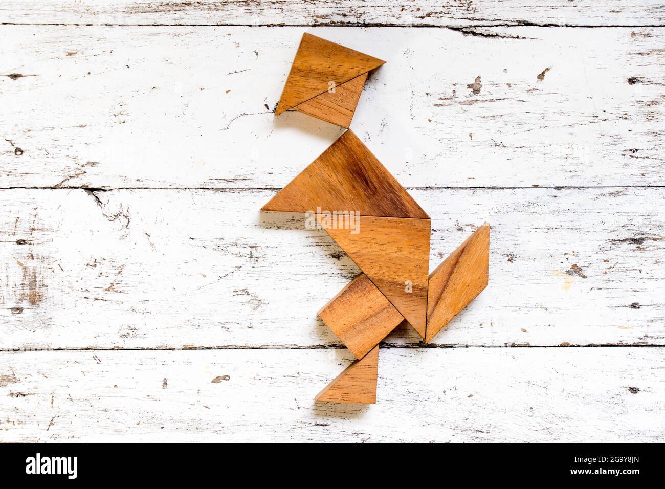 Tangram puzzle in happy running man shape on old white wood background ...