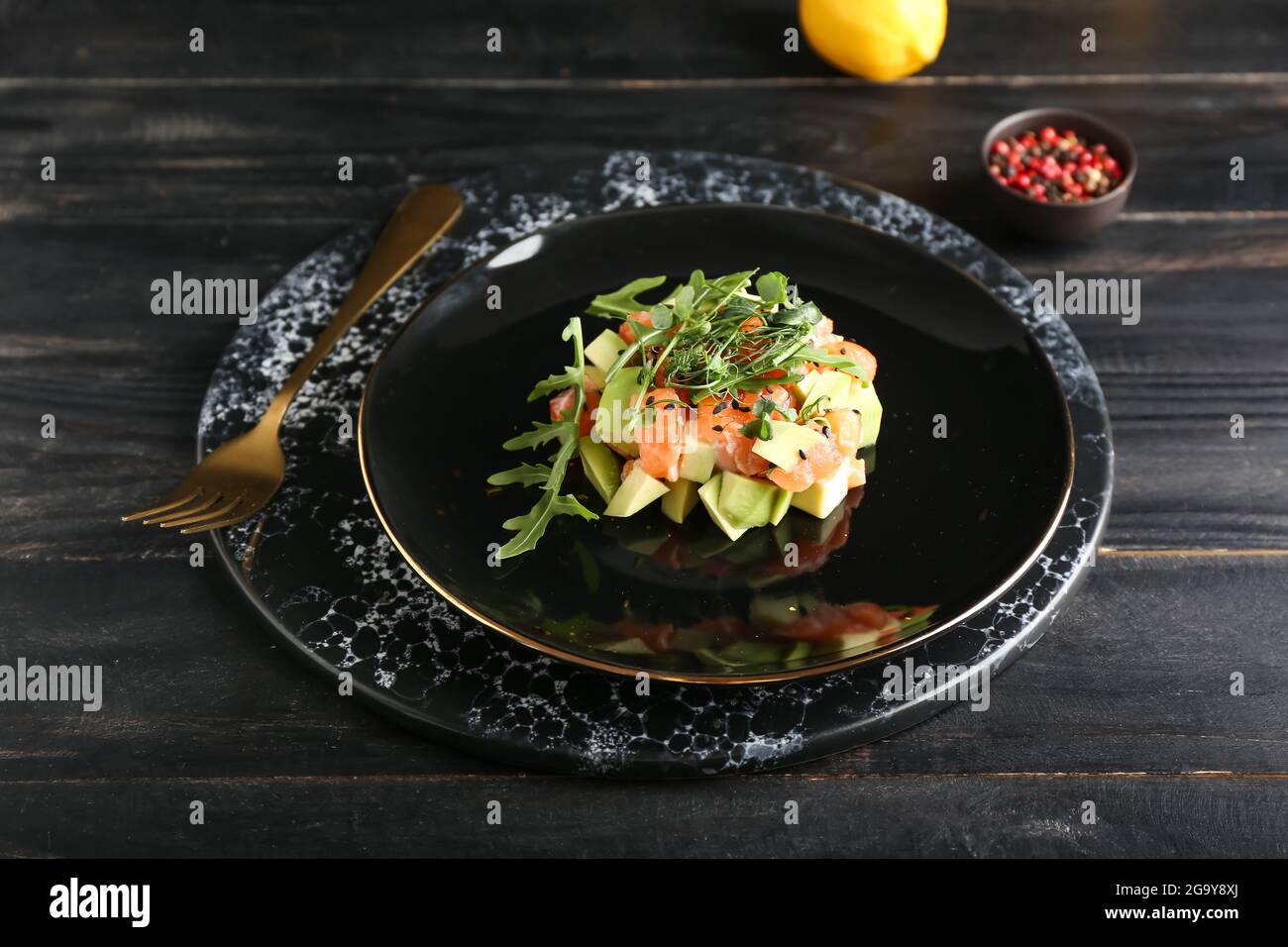 Delicious salmon tartar on dark wooden background Stock Photo - Alamy
