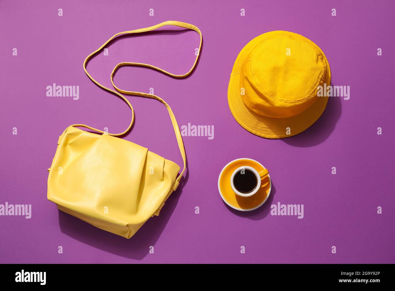 Stylish hat with bag and cup of coffee on color background Stock Photo ...