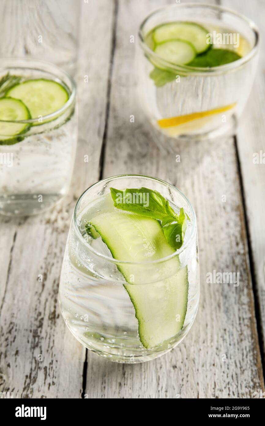 Glasses with cucumber lemonade on light wooden background Stock Photo ...